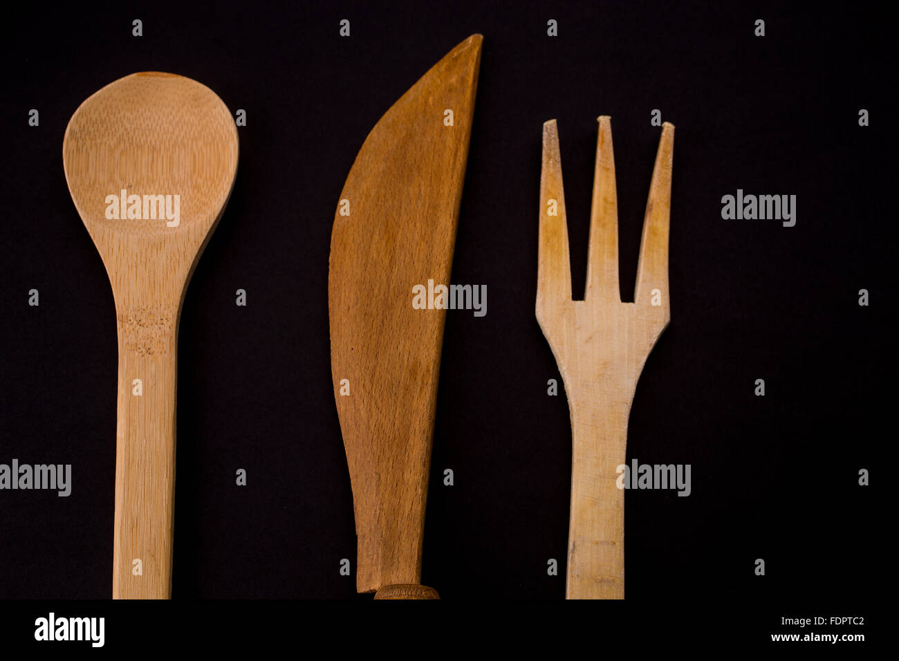 Still life of wooden carved cutlery isolated on black Stock Photo - Alamy