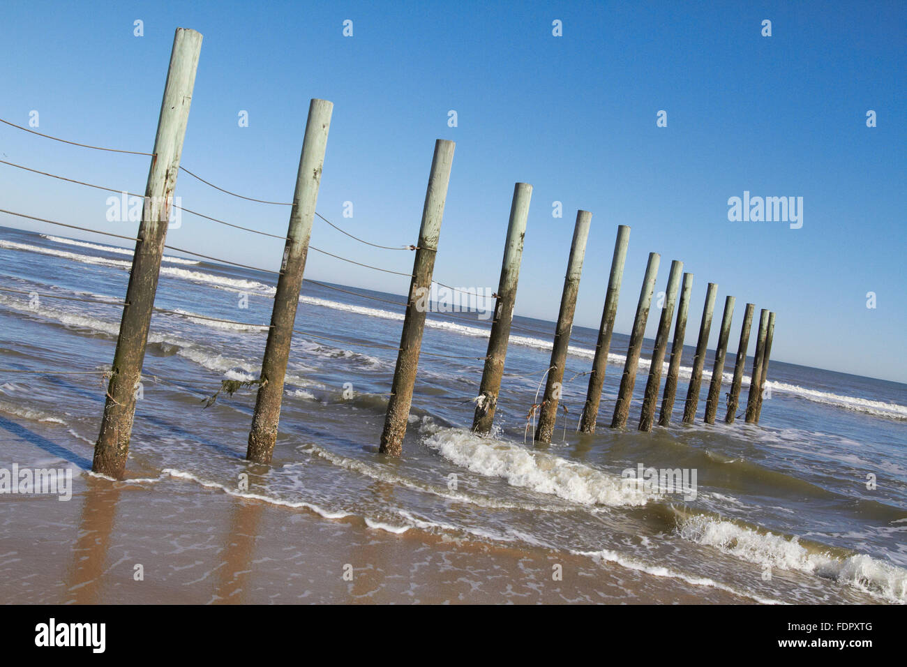 Fence leading into the ocean Stock Photo - Alamy