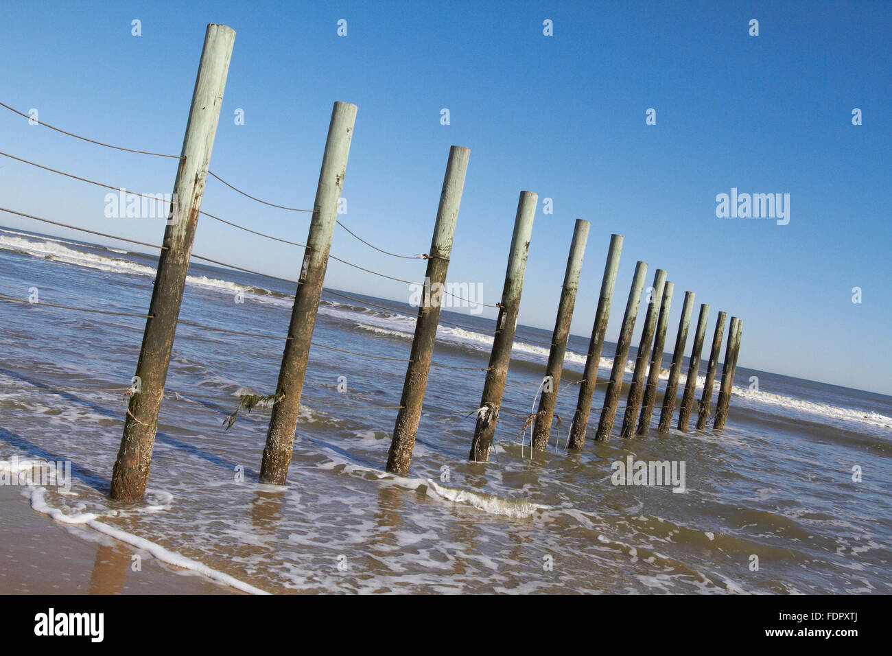 Fence leading into the ocean Stock Photo - Alamy