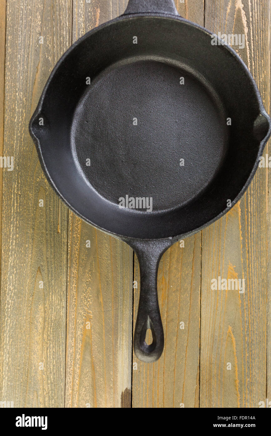 Cast iron skillet on rustic wood table Stock Photo - Alamy