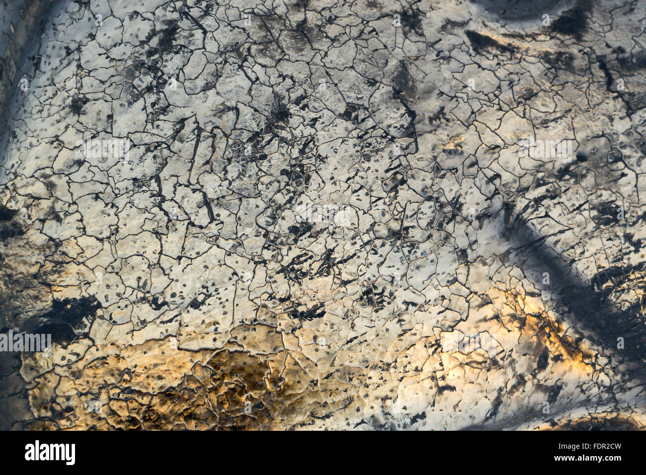 Frozen ice patterns with light filtering through the cracks. The ...