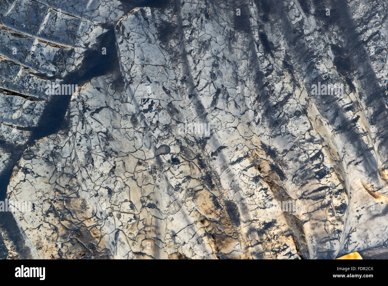 Frozen ice patterns with light filtering through the cracks. The ...