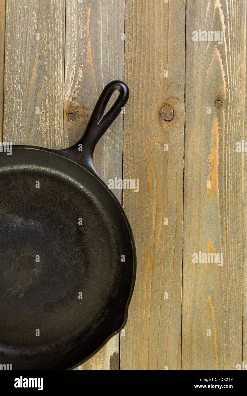 Cast iron skillet on rustic wood table Stock Photo - Alamy