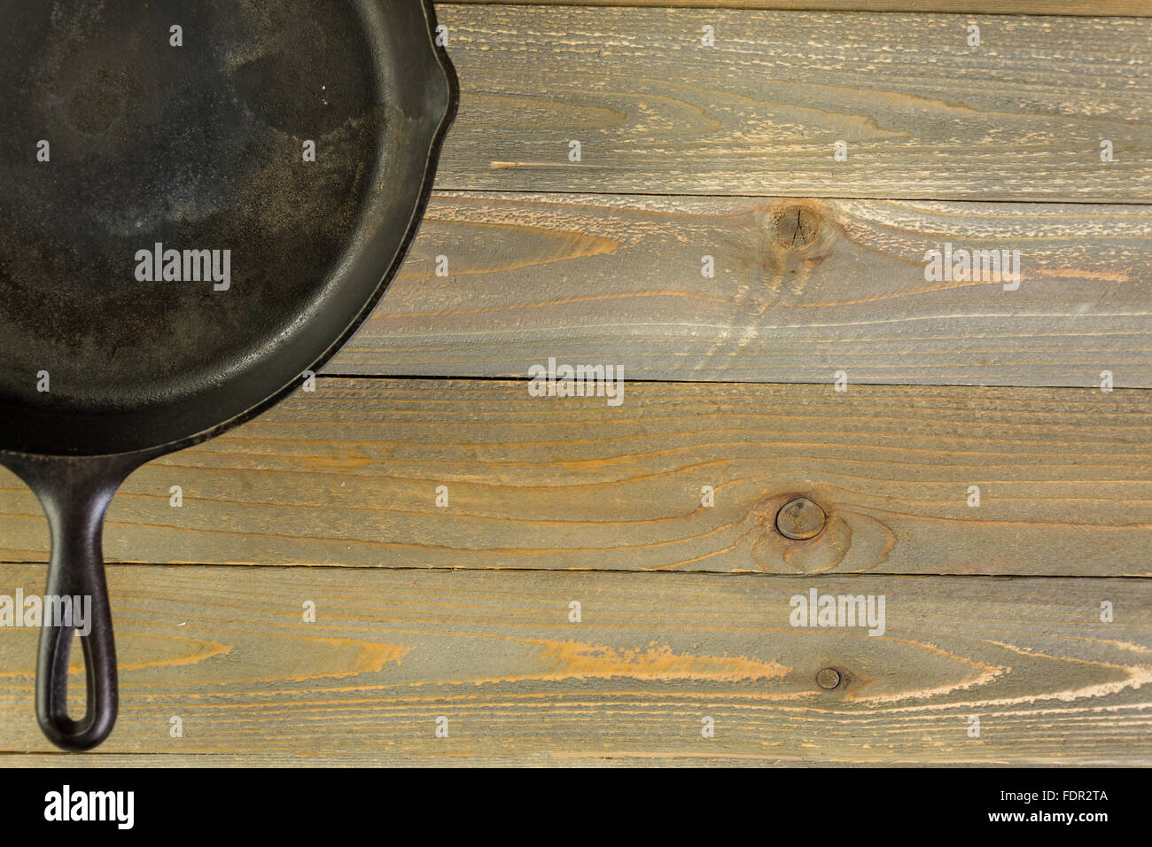 Cast iron skillet on rustic wood table Stock Photo - Alamy