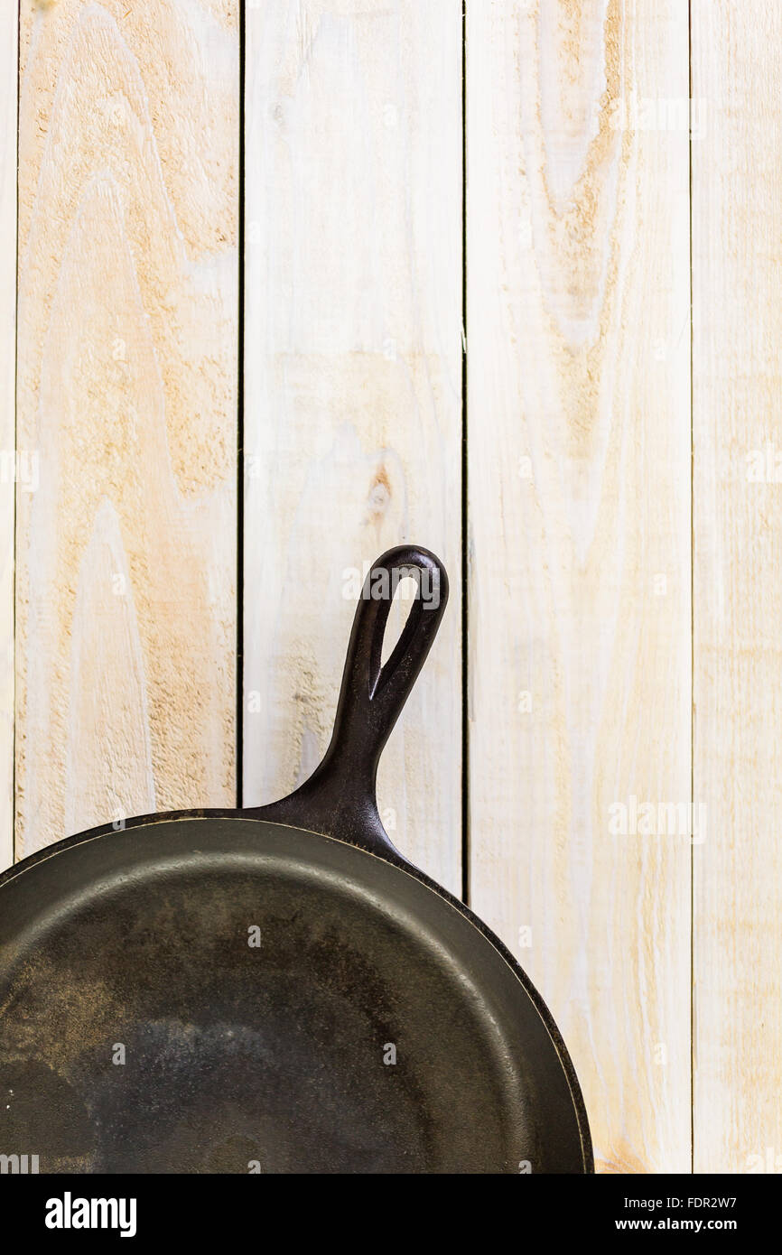 Cast iron skillet on rustic wood table Stock Photo - Alamy