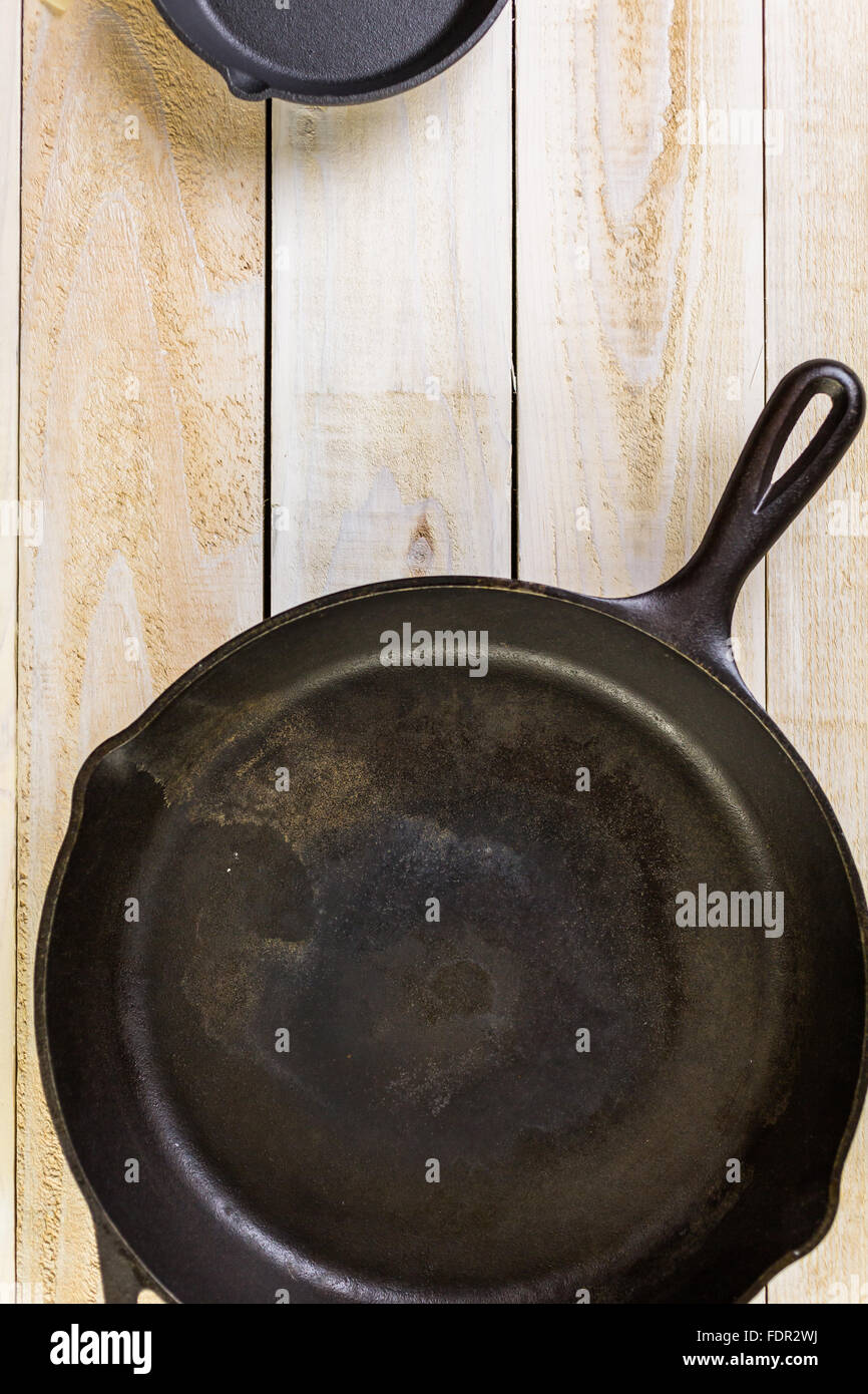 Cast iron skillet on rustic wood table Stock Photo - Alamy