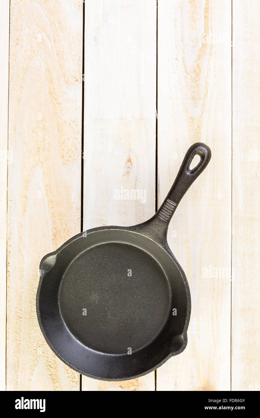 Cast iron skillet on rustic wood table Stock Photo - Alamy