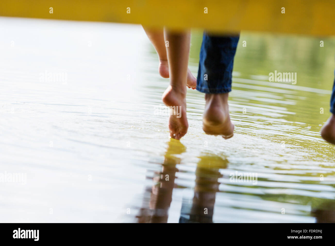 Close up of people's feet sitting on bridge Stock Photo - Alamy