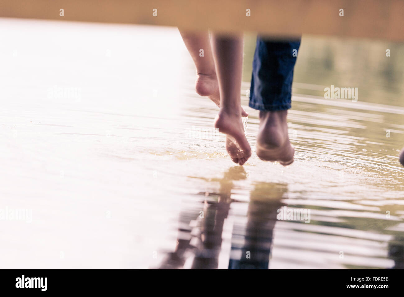 Close up of people's feet sitting on bridge Stock Photo - Alamy