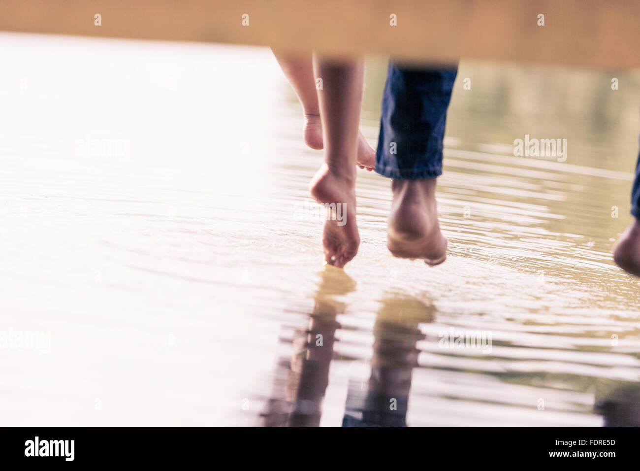 Close up of people's feet sitting on bridge Stock Photo - Alamy