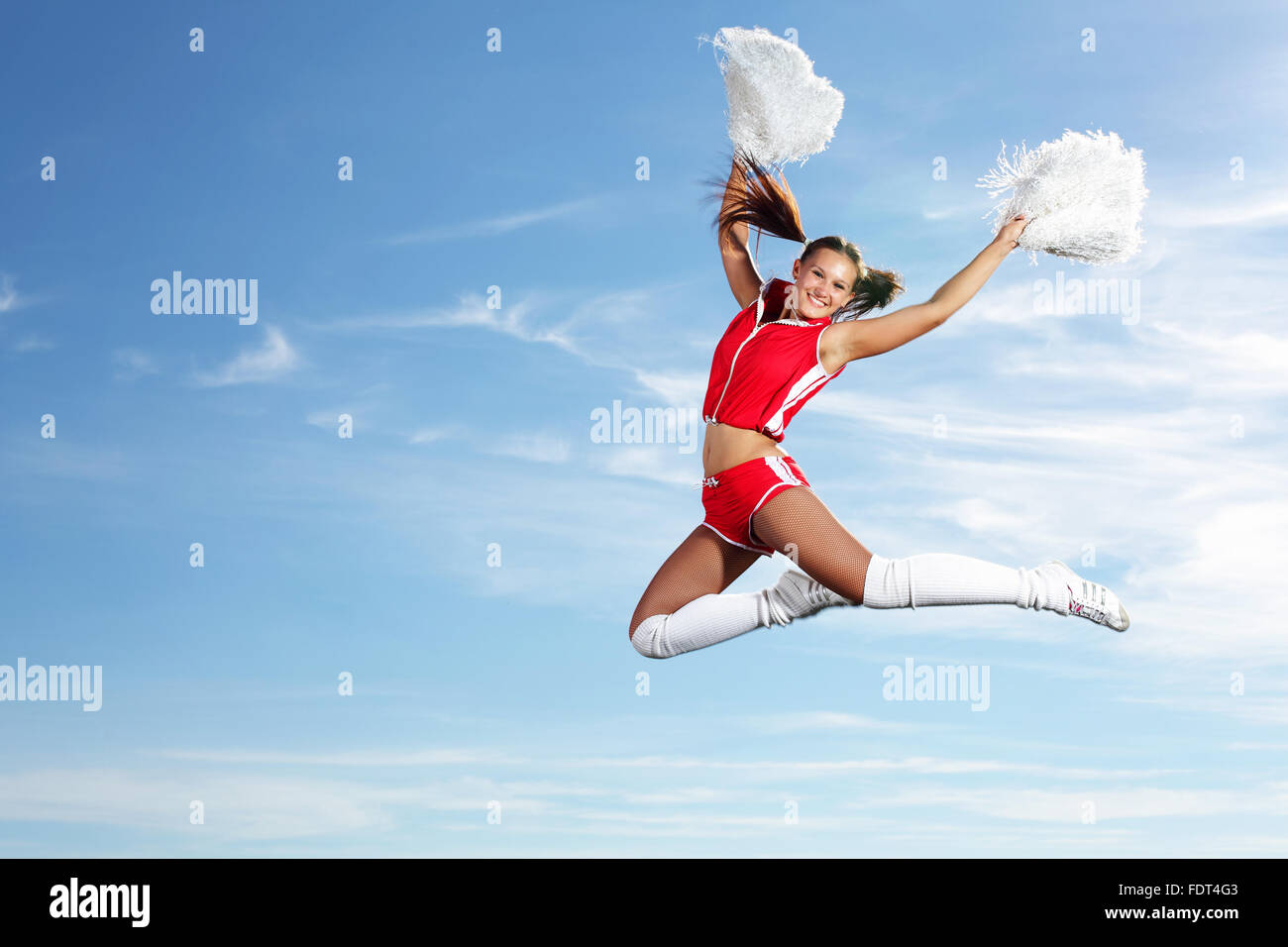 Young beautiful female cheerleader in uniform jumping high Stock Photo ...