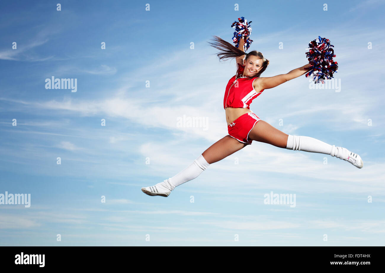 Young beautiful female cheerleader in uniform jumping high Stock Photo ...