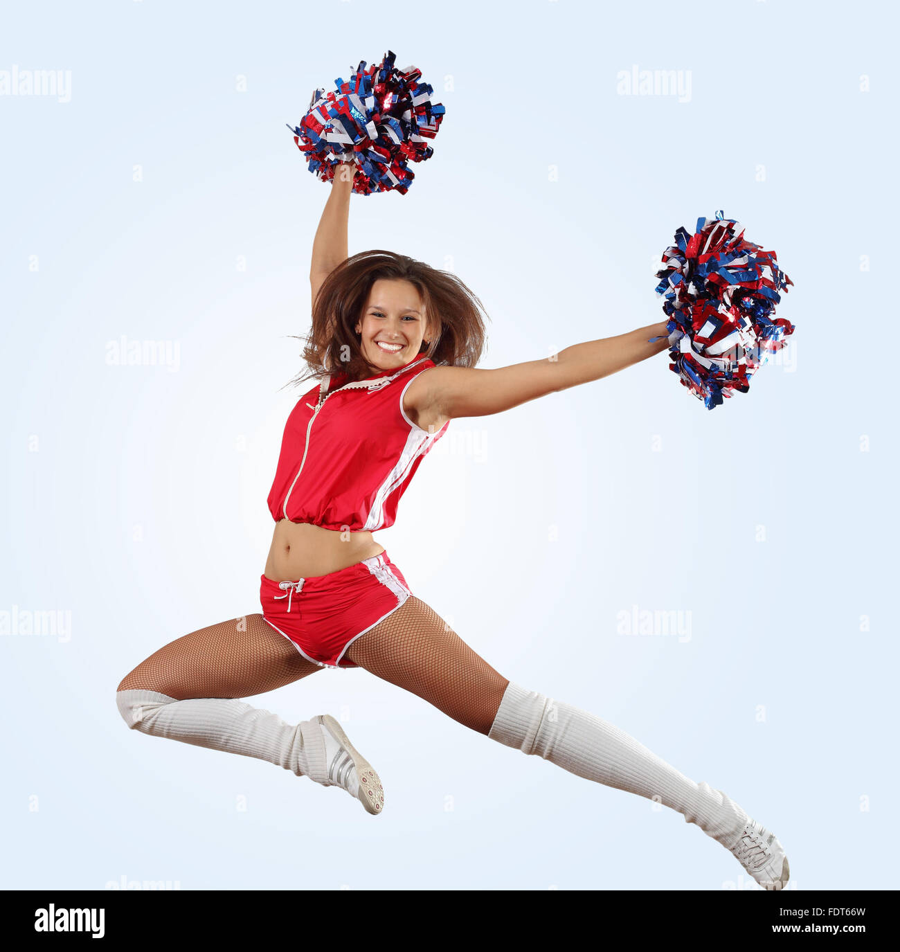 Uniformed cheerleader jumps high in the air isolated on white Stock ...