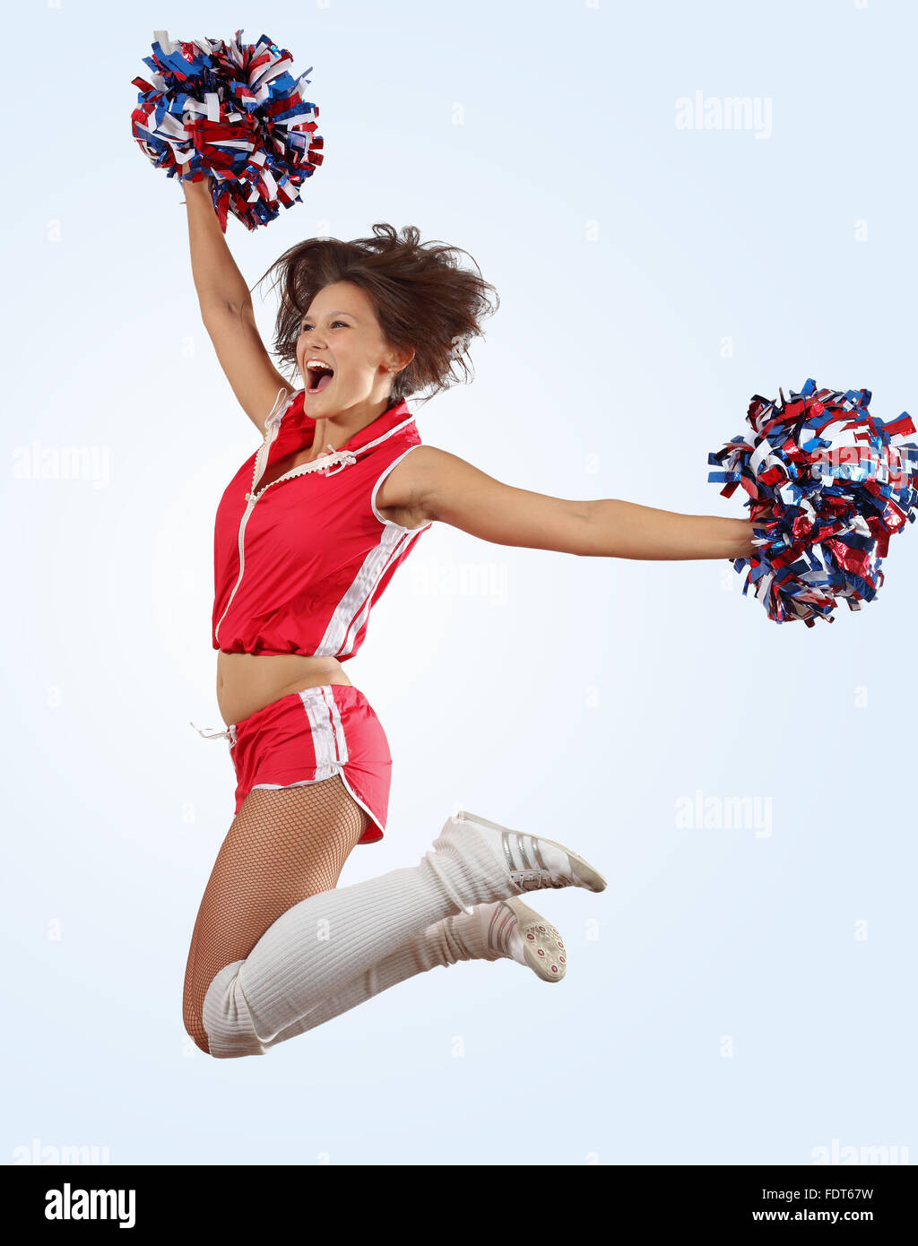 Uniformed cheerleader jumps high in the air isolated on white Stock ...