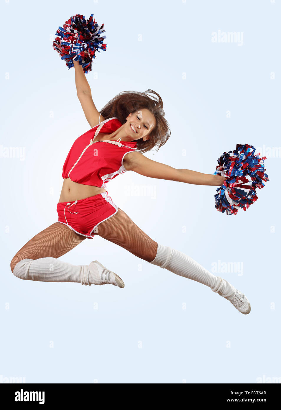 Uniformed cheerleader jumps high in the air isolated on white Stock ...