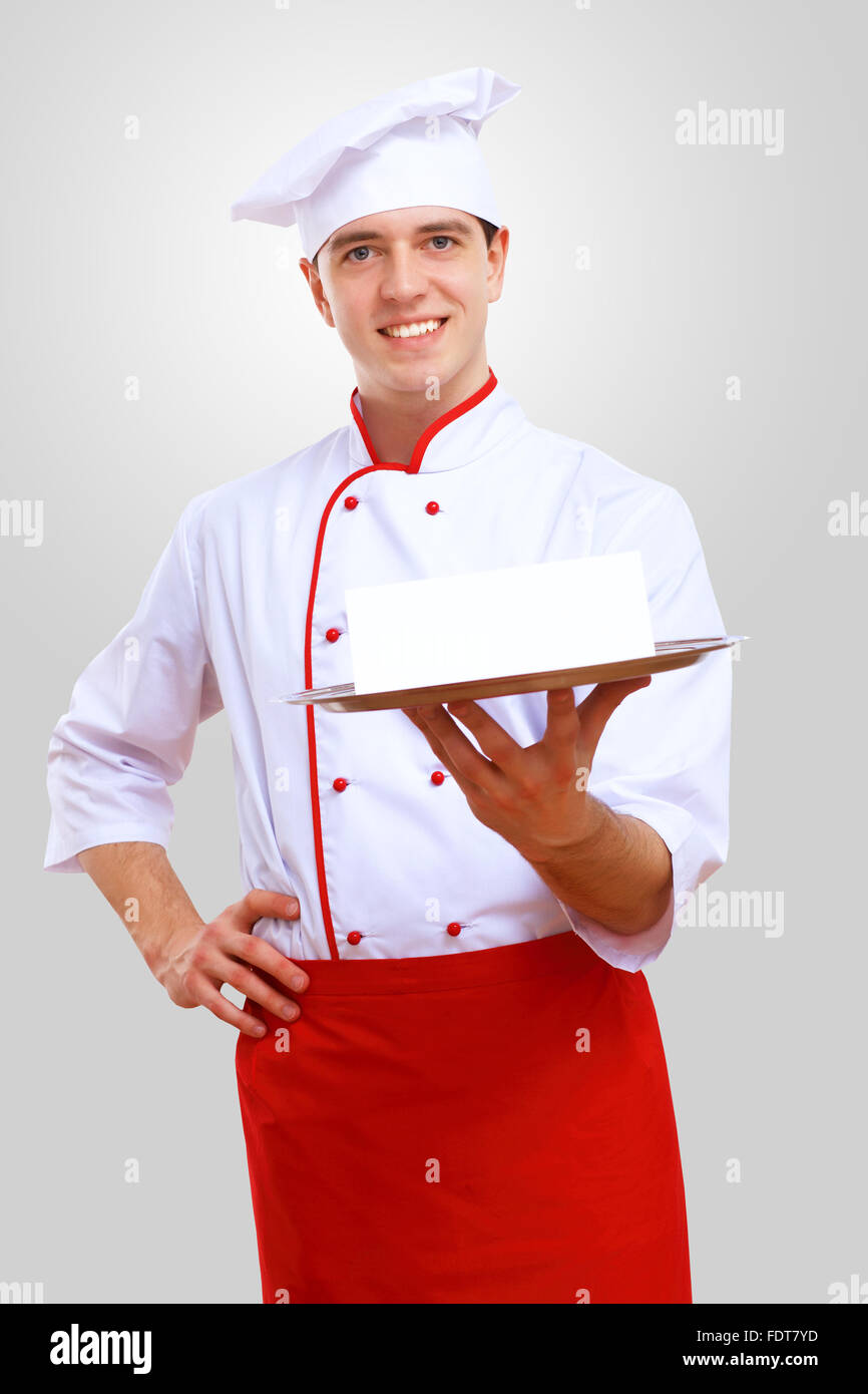 Young male chef in red apron against grey background Stock Photo - Alamy