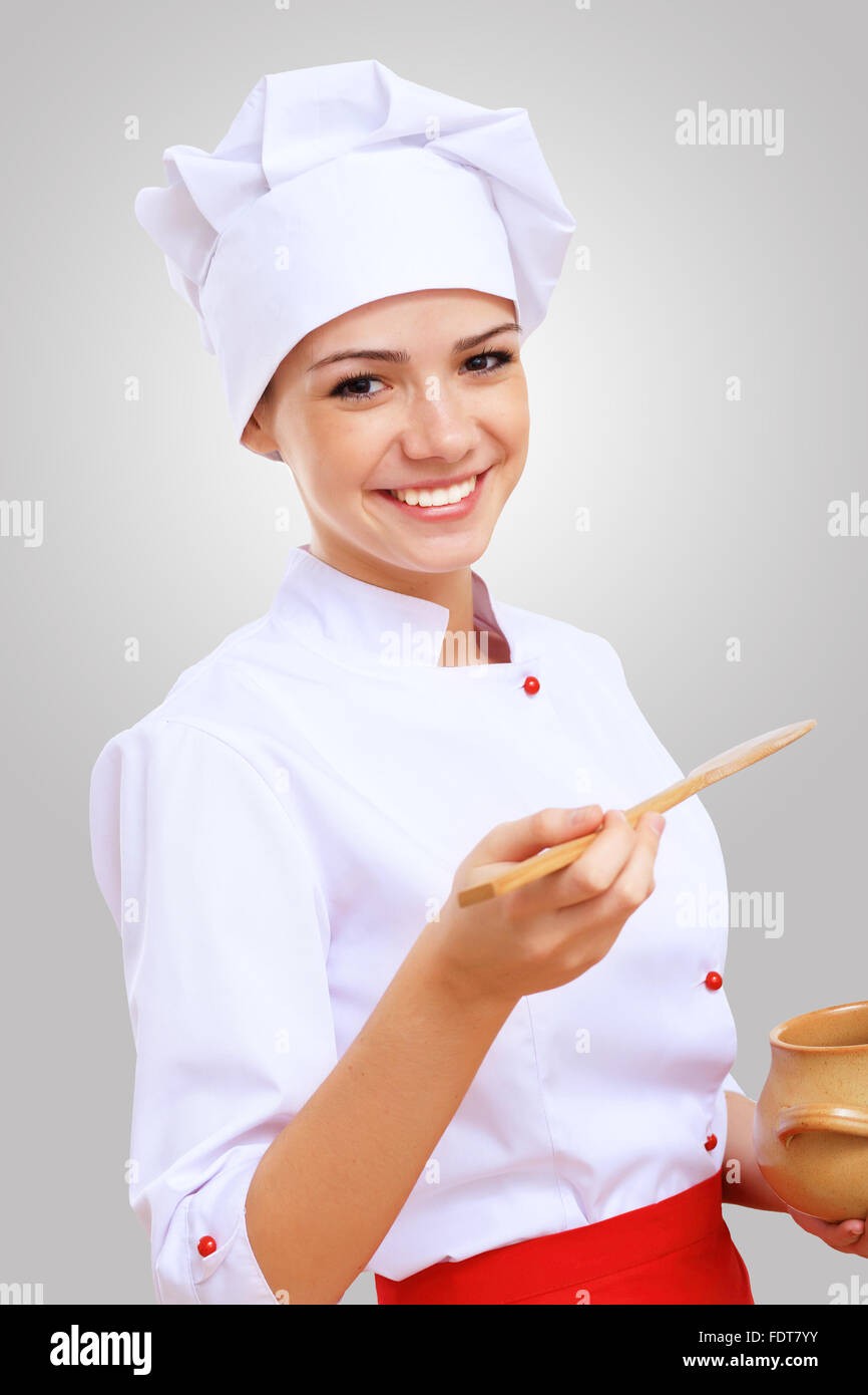 Young female chef in red apron against grey background Stock Photo - Alamy