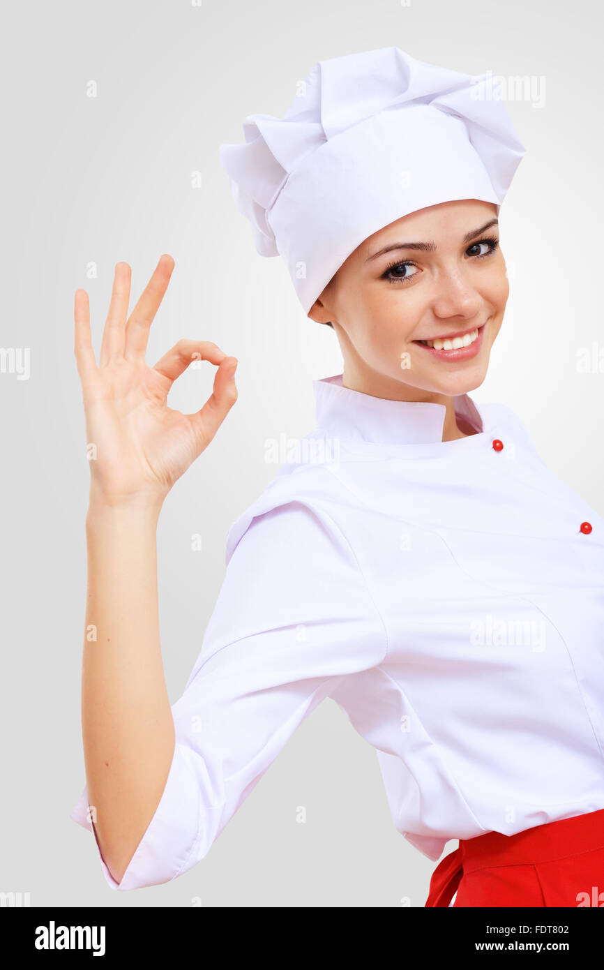 Young female chef in red apron against grey background Stock Photo - Alamy