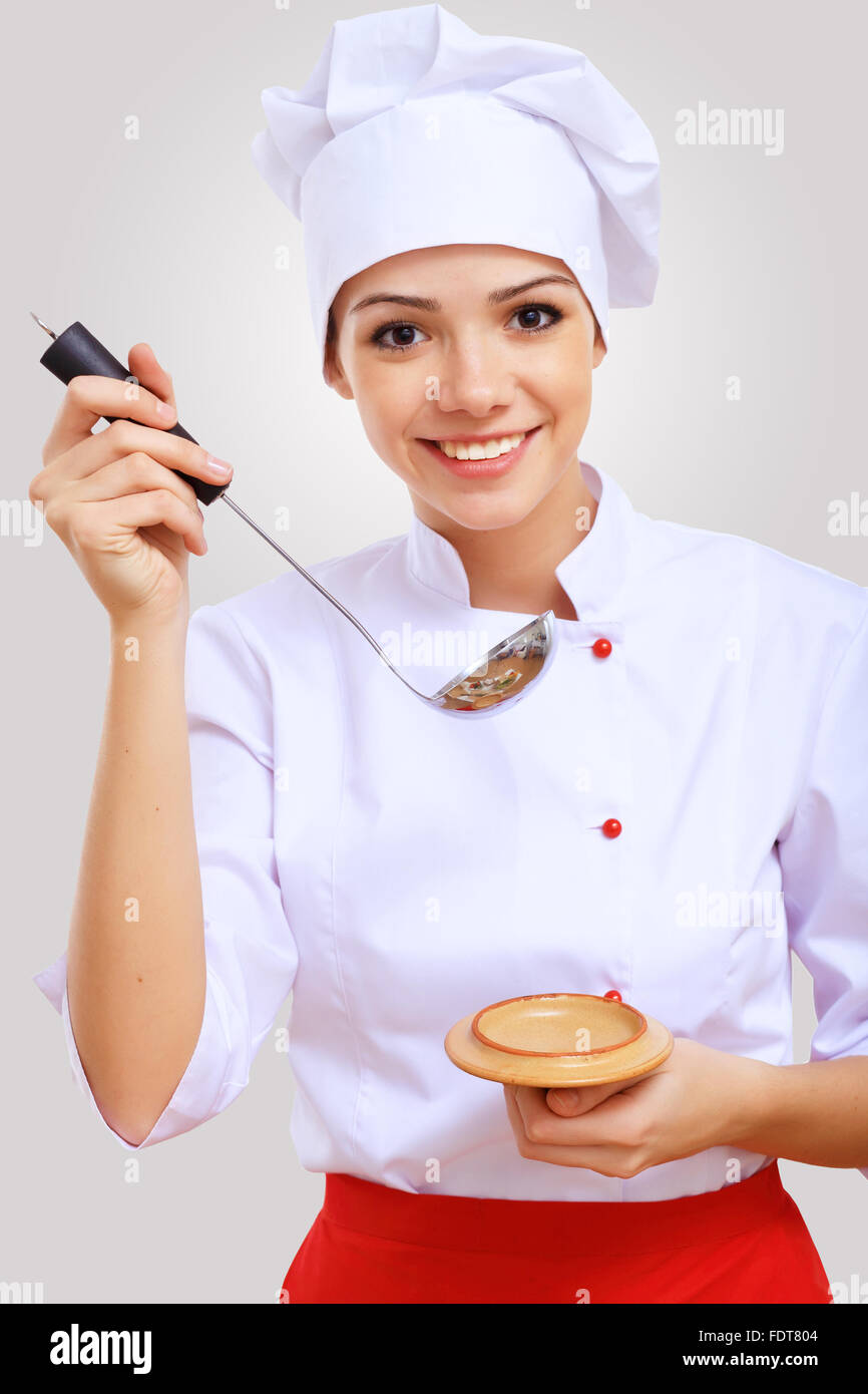 Young female chef in red apron against grey background Stock Photo - Alamy