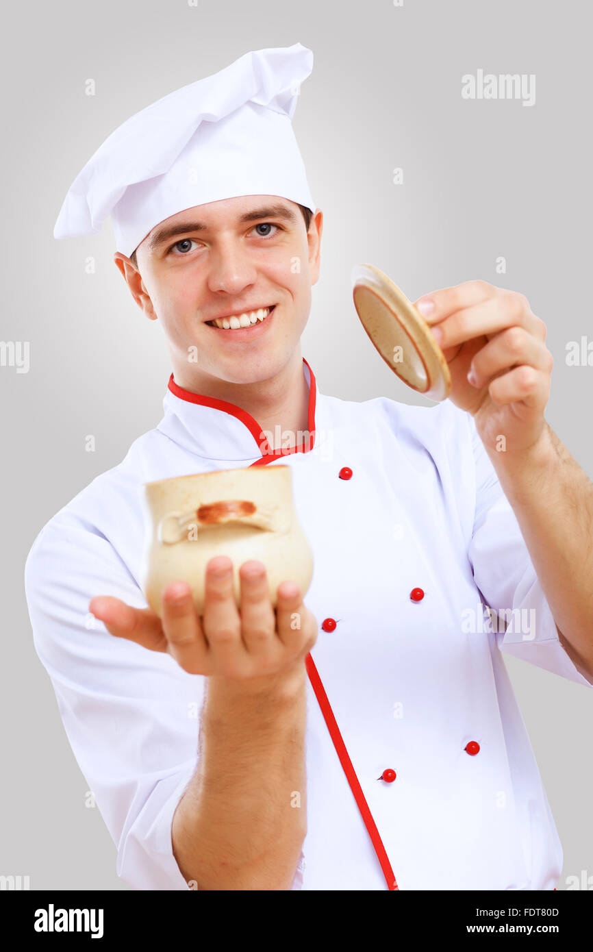 Young male chef in red apron against grey background Stock Photo - Alamy