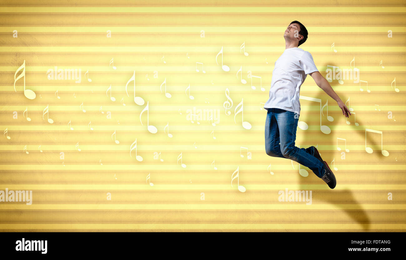 pretty modern slim hip-hop style man jumping dancing on a colour ...