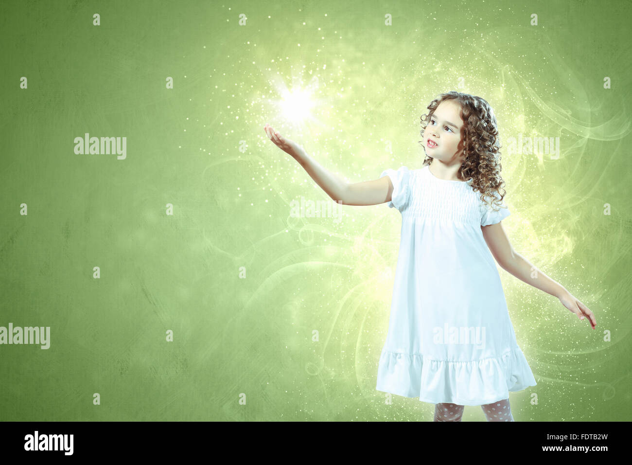 Little girl with magic lights and shining around Stock Photo - Alamy