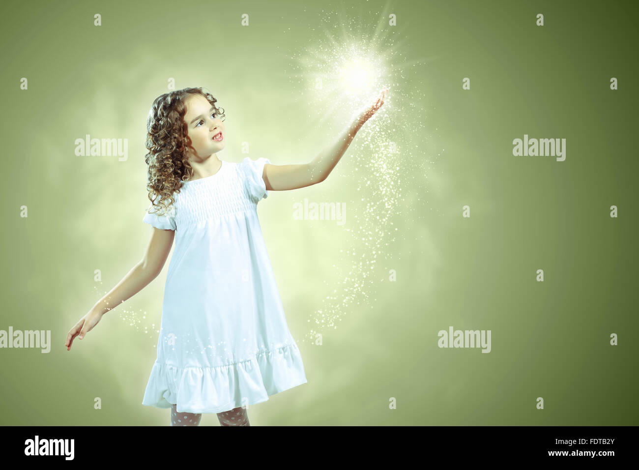 Little girl with magic lights and shining around Stock Photo - Alamy