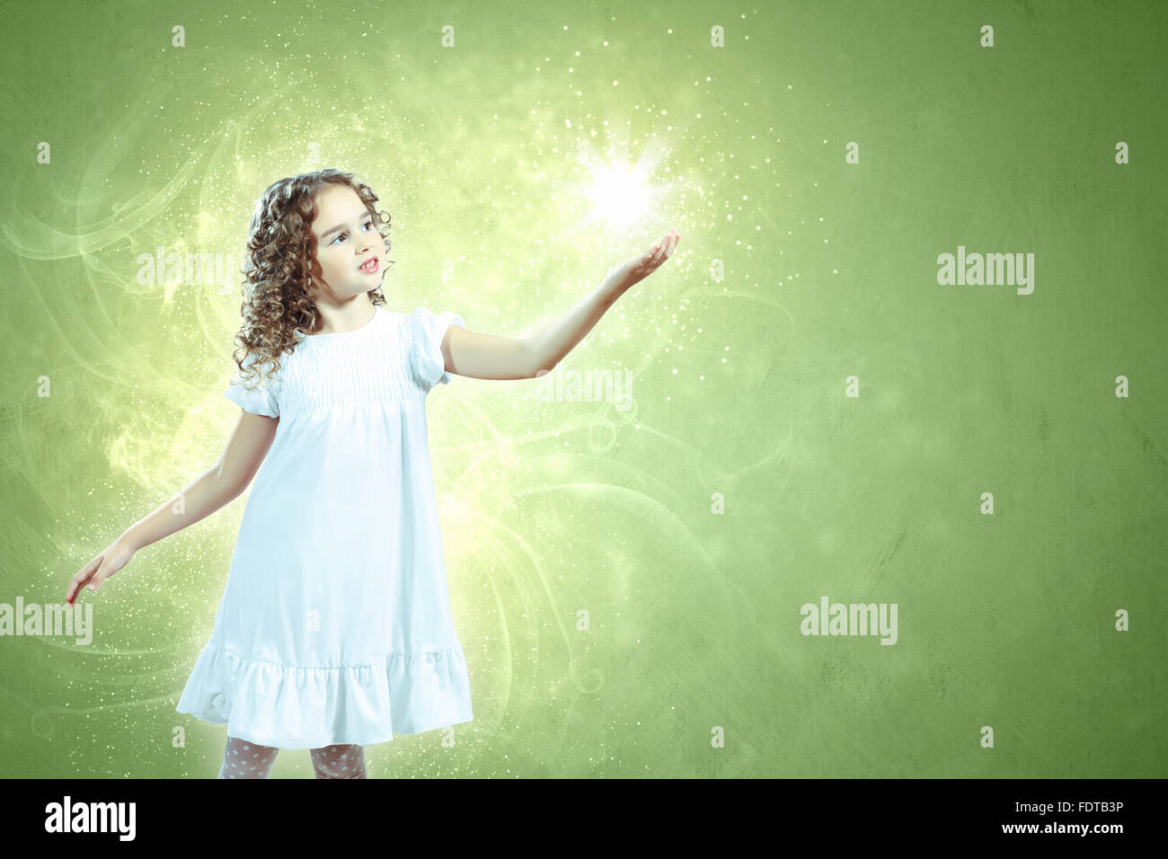 Little girl with magic lights and shining around Stock Photo - Alamy
