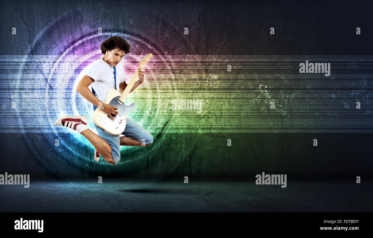 young man playing on electro guitar and jumping Stock Photo - Alamy