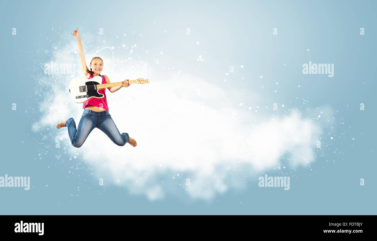 young woman playing on electro guitar and jumping Stock Photo - Alamy
