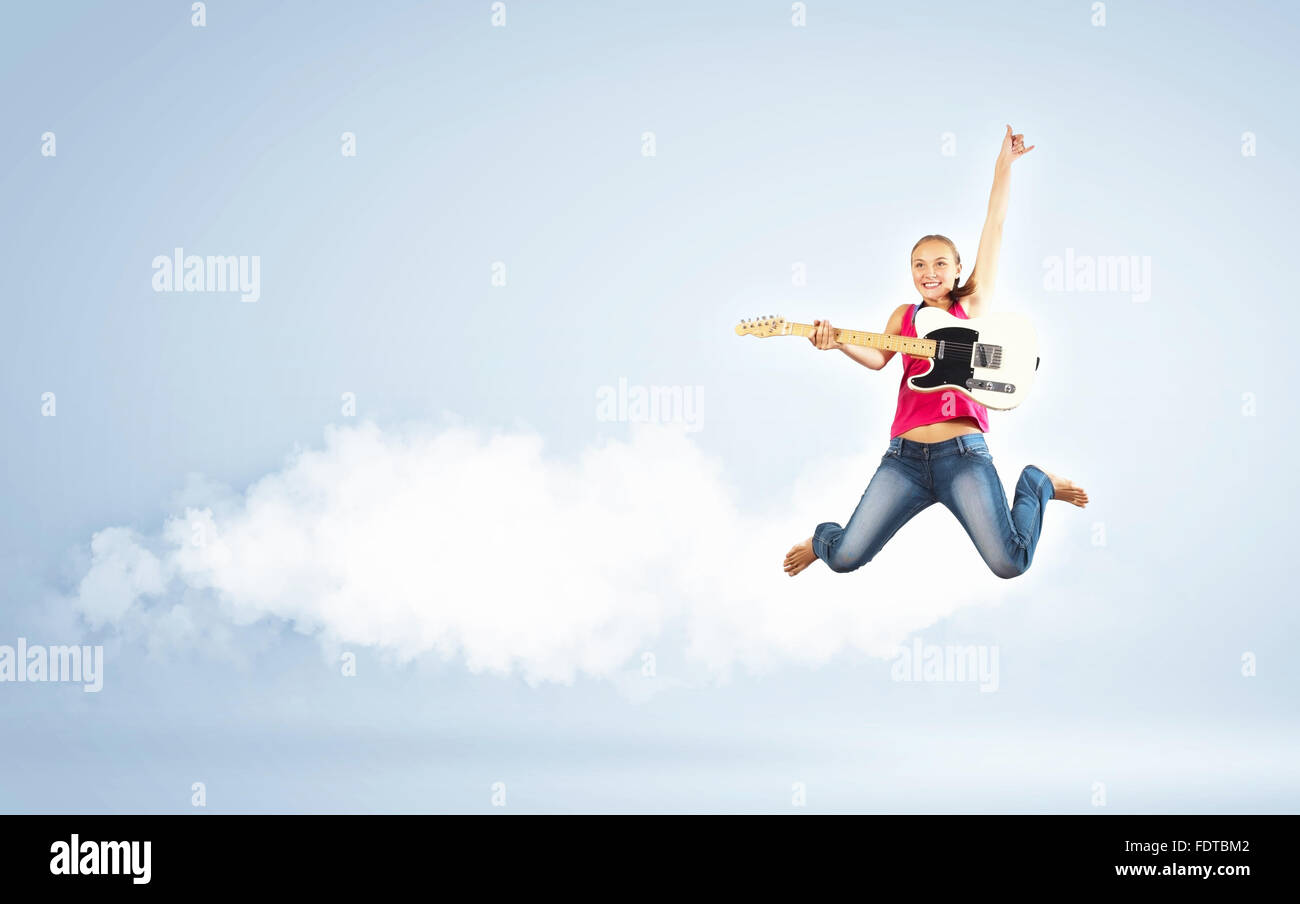 young woman playing on electro guitar and jumping Stock Photo - Alamy