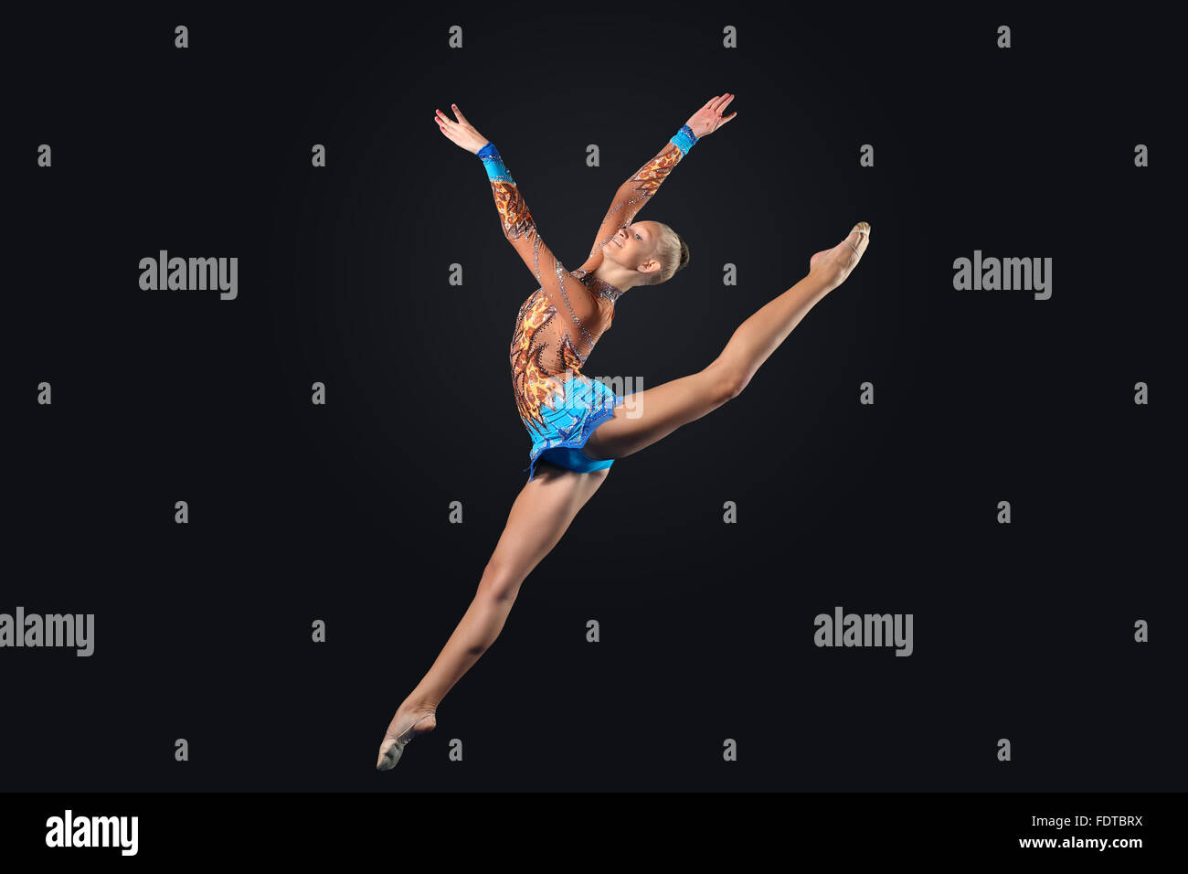 Young cute woman in gymnast suit show athletic skill on black ...