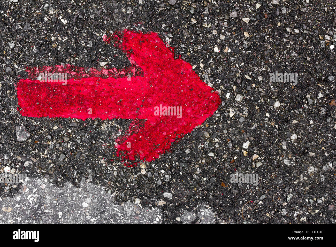A red arrow pointing to the right, painted with red paint on the ...