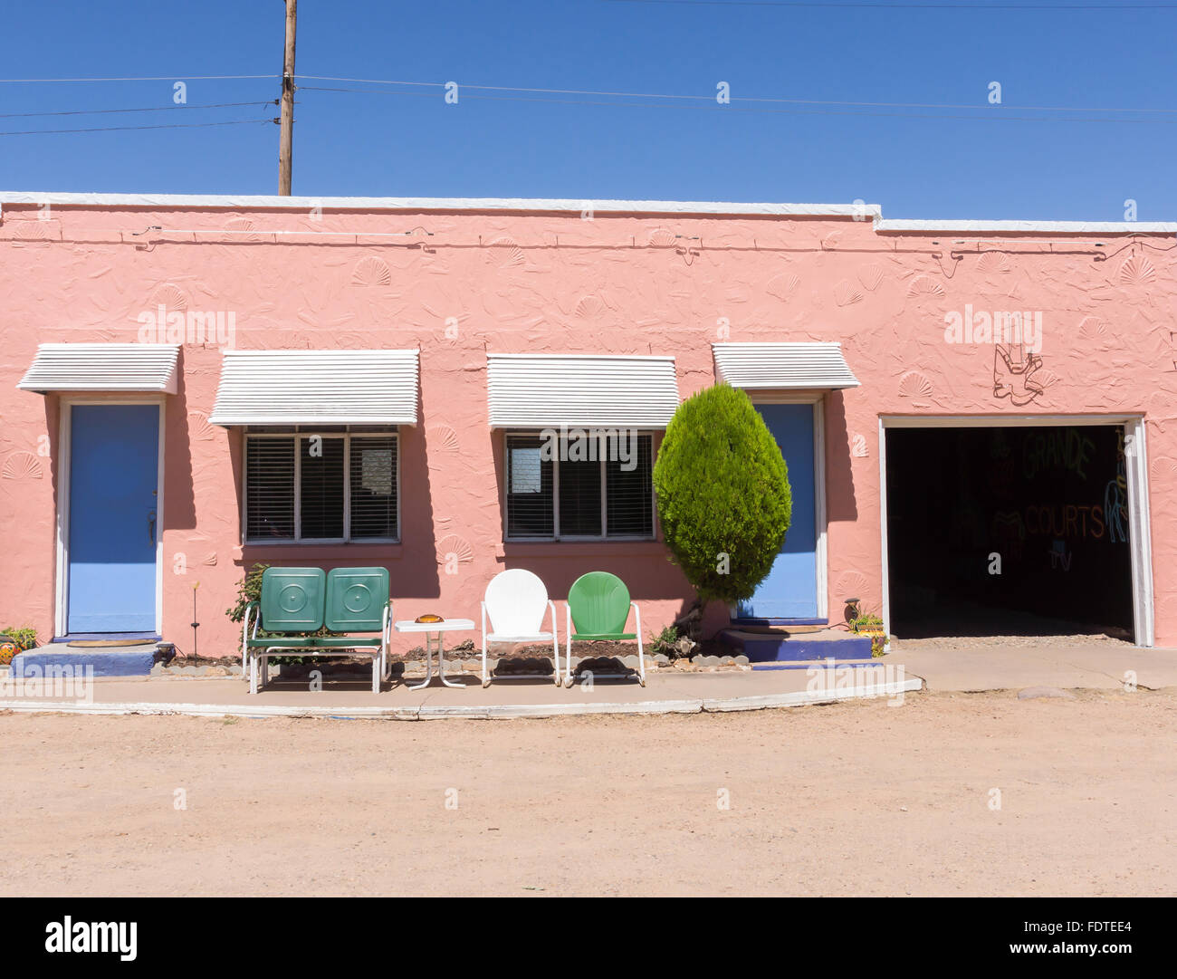 Concrete stucco exterior in pink with blue doors and retro chairs ...