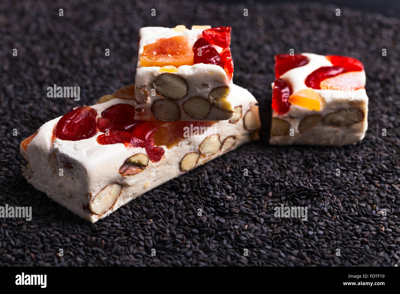 Soft nougat with tropical fruit on black sesame Stock Photo - Alamy