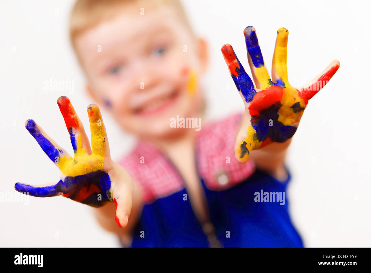 little child with hands painted in colorful paints ready for hand ...