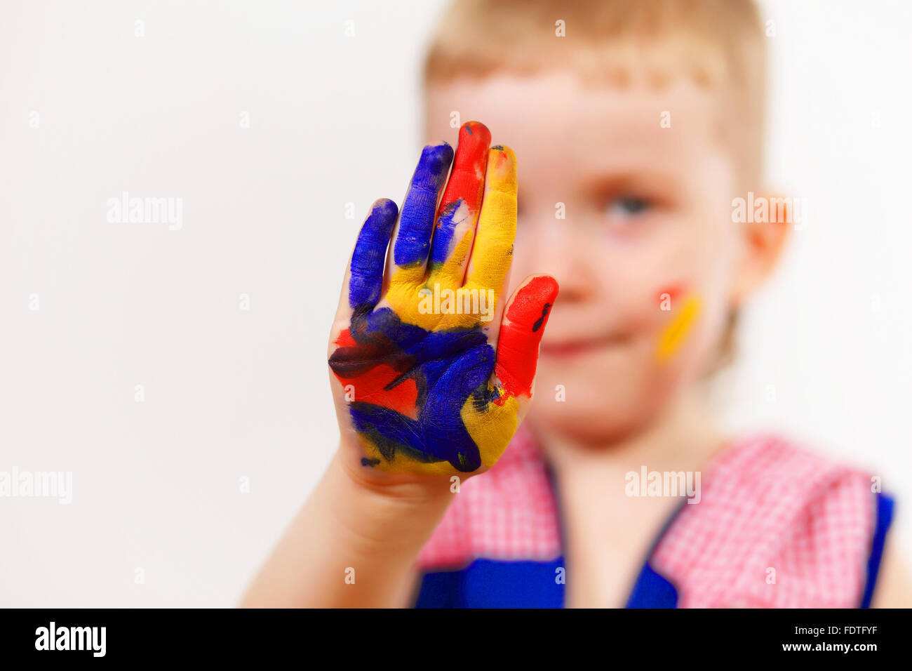 little child with hands painted in colorful paints ready for hand ...