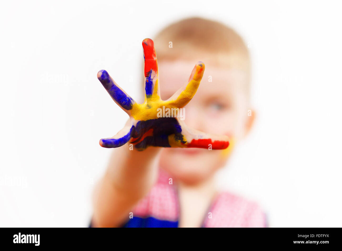 little child with hands painted in colorful paints ready for hand ...