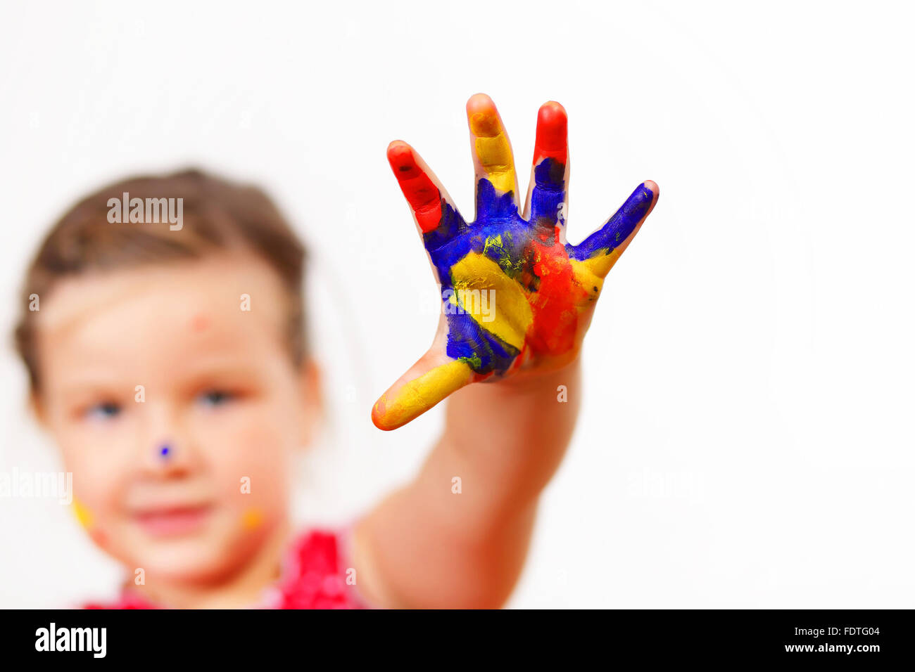 little child with hands painted in colorful paints ready for hand ...
