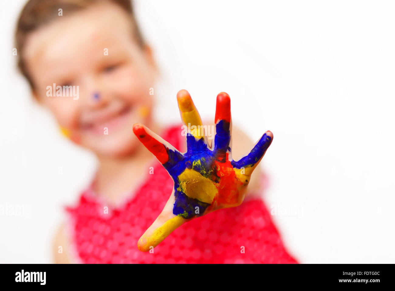 little child with hands painted in colorful paints ready for hand ...