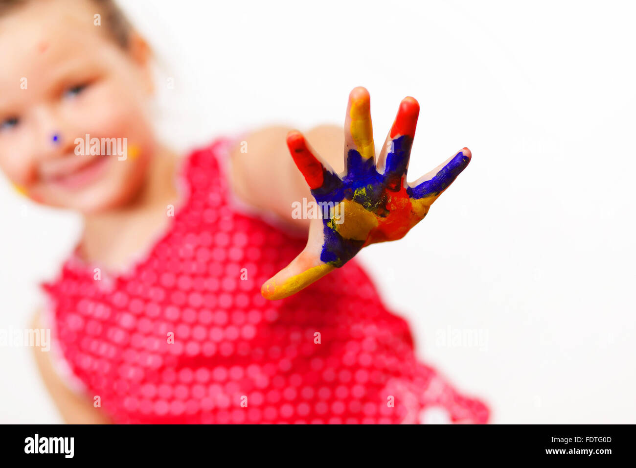 little child with hands painted in colorful paints ready for hand ...