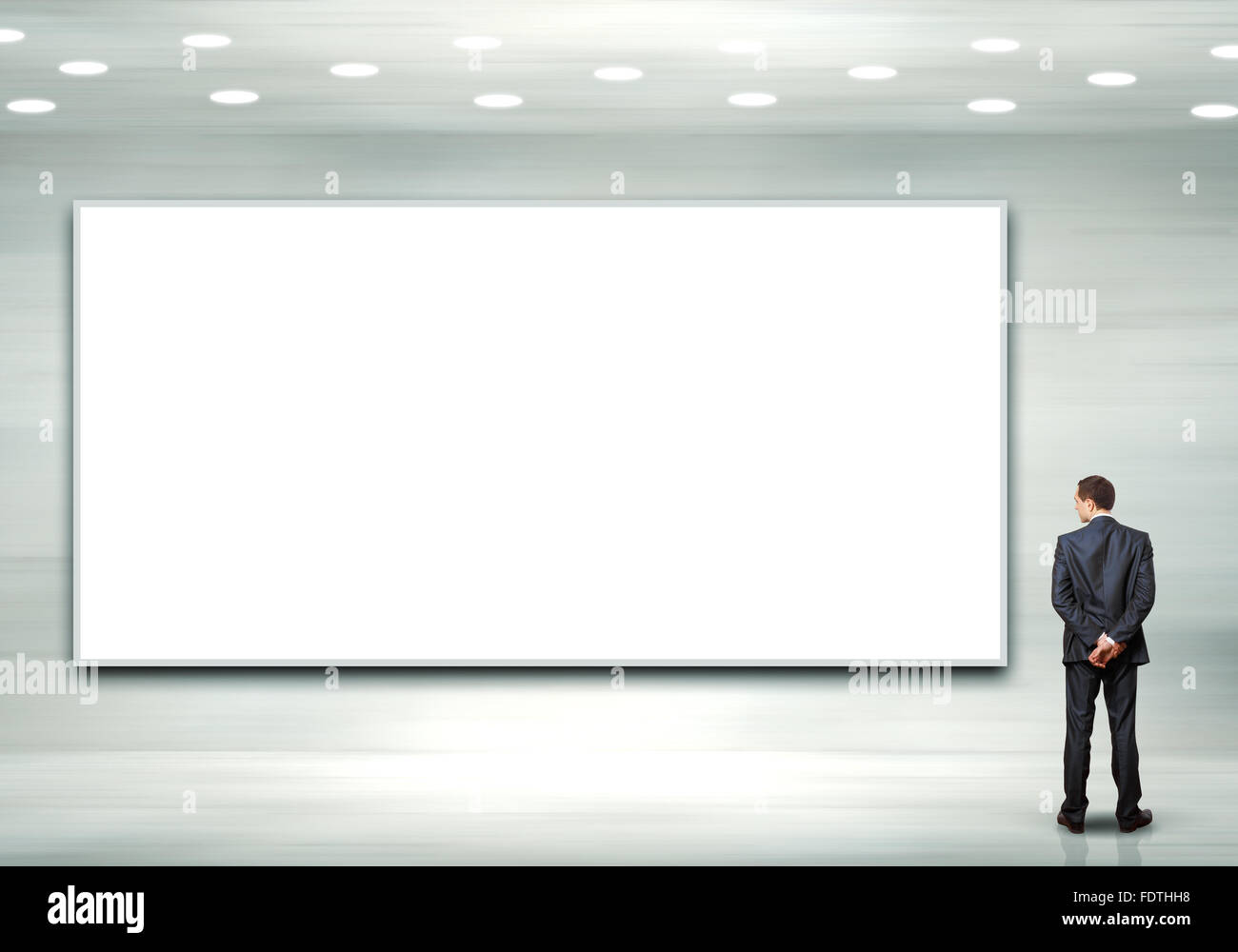 Business person standing near a white blank billboard Stock Photo - Alamy