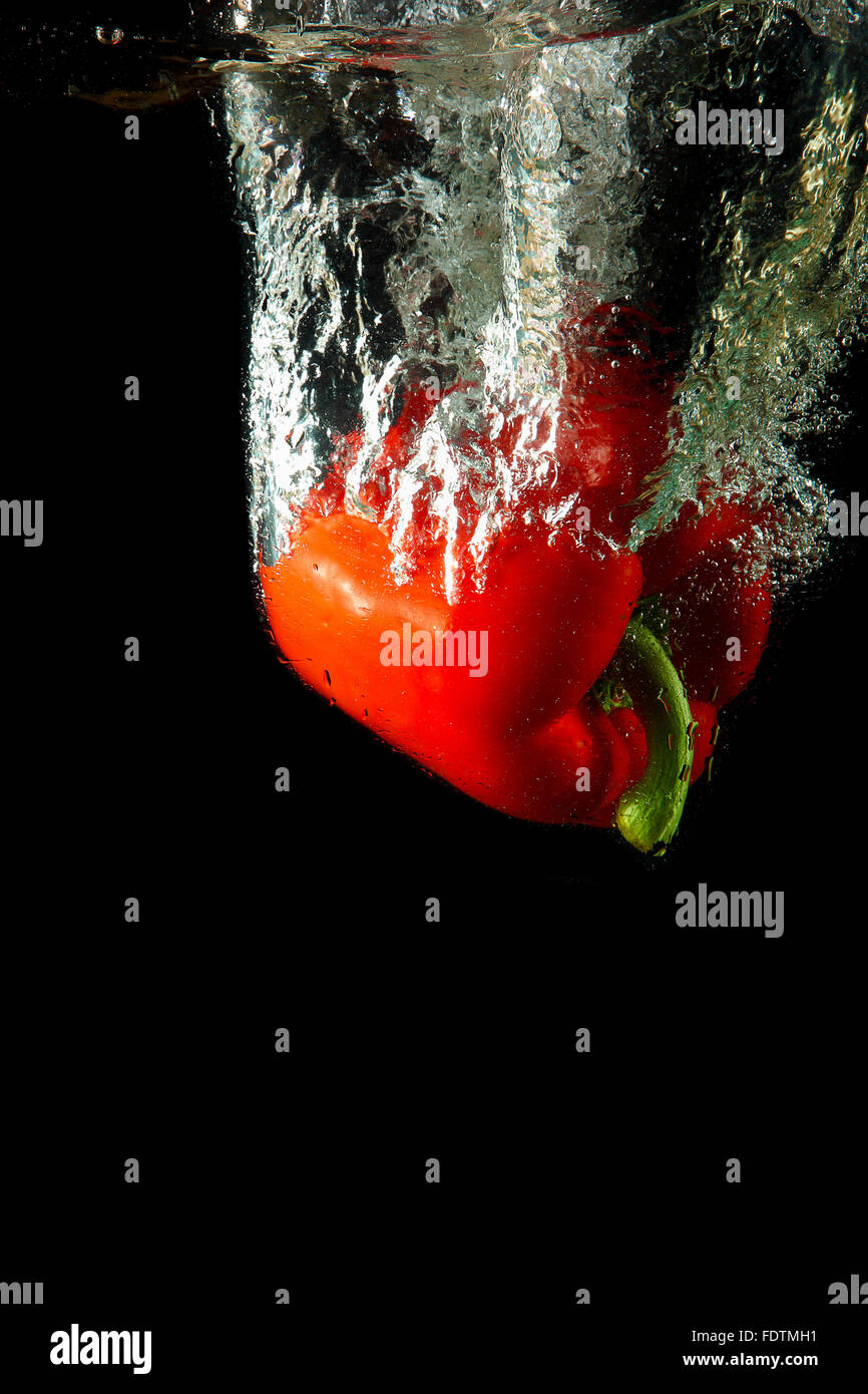 Colored red paprika in water splashes on black background Stock Photo ...