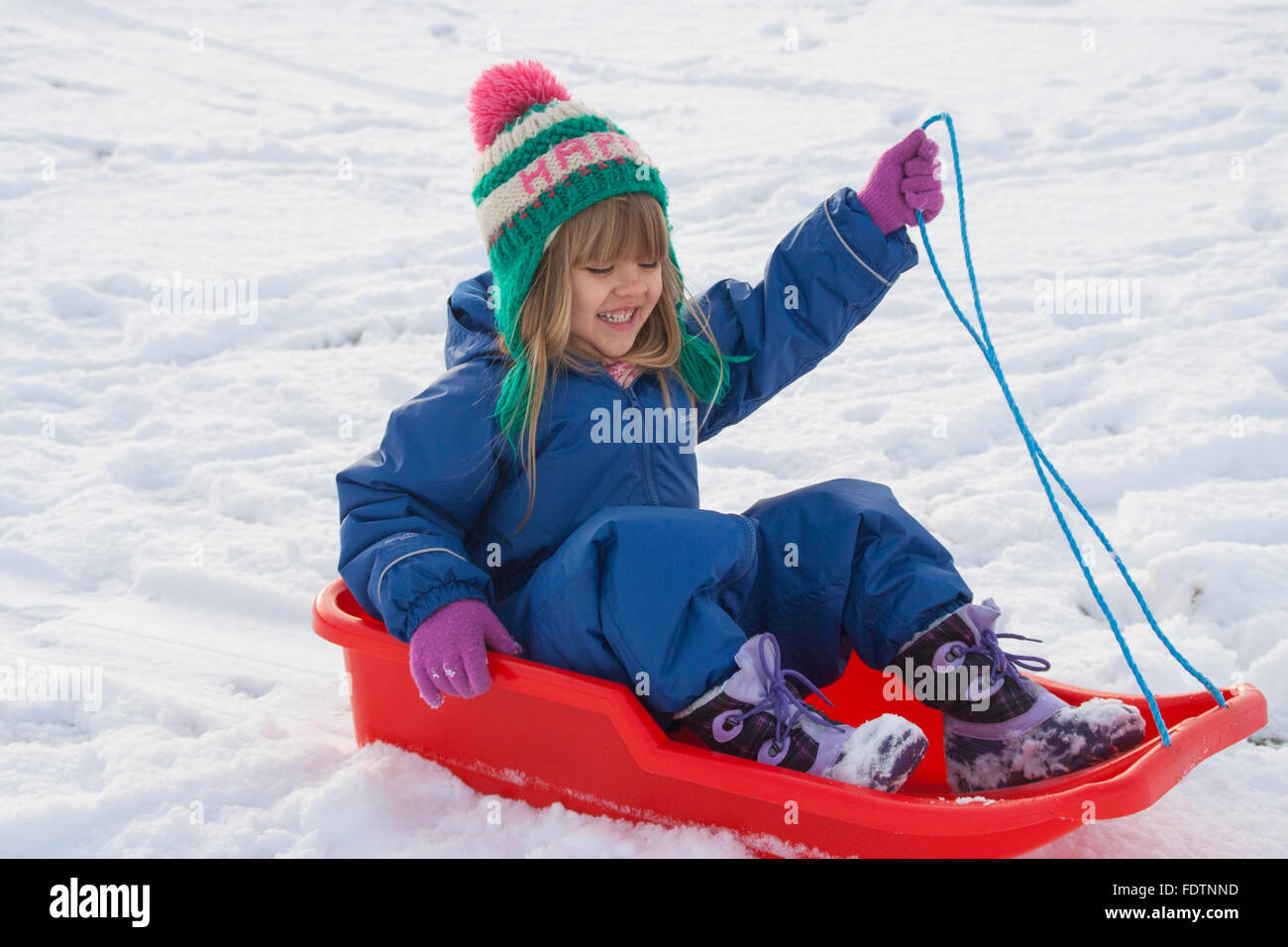 Little girl sledging down hill in Neverland Play Park, Kirriemuir ...