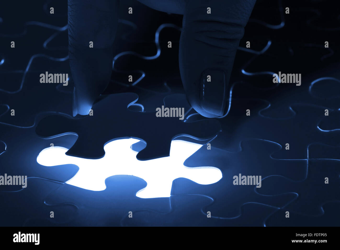 puzzle piece coming down into its place Stock Photo - Alamy