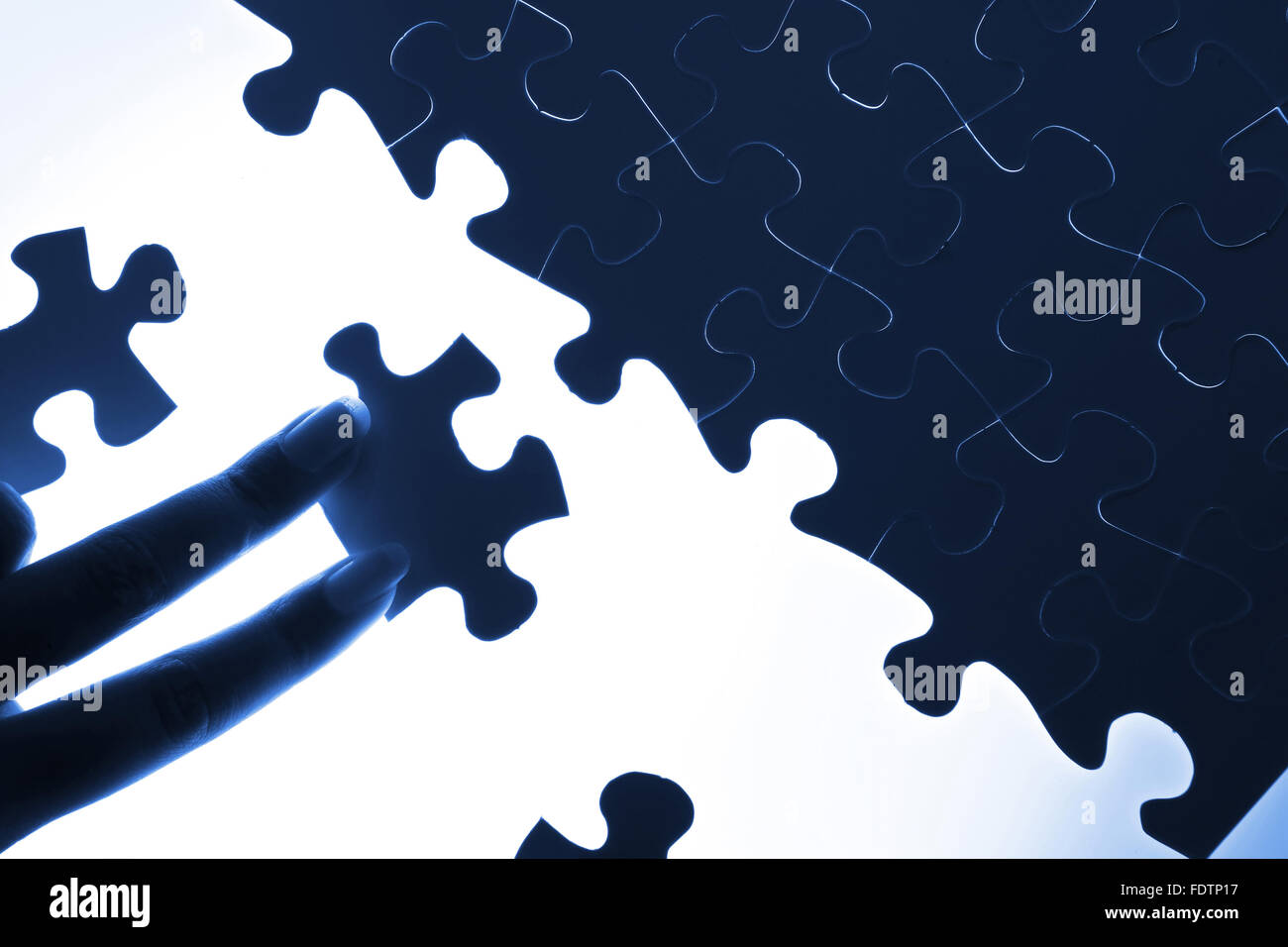puzzle piece coming down into its place Stock Photo - Alamy