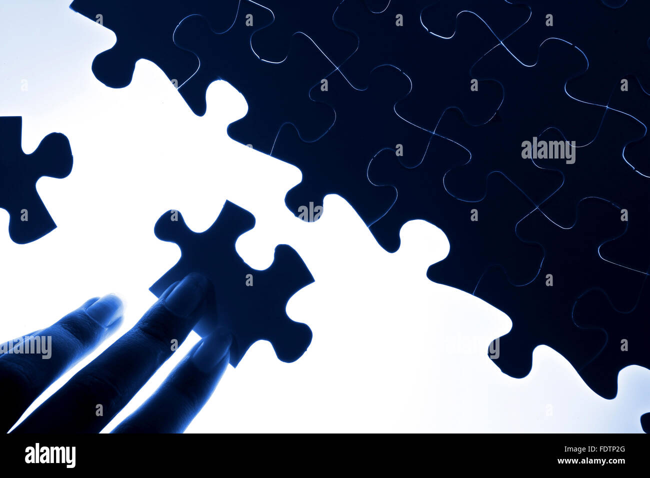puzzle piece coming down into its place Stock Photo - Alamy