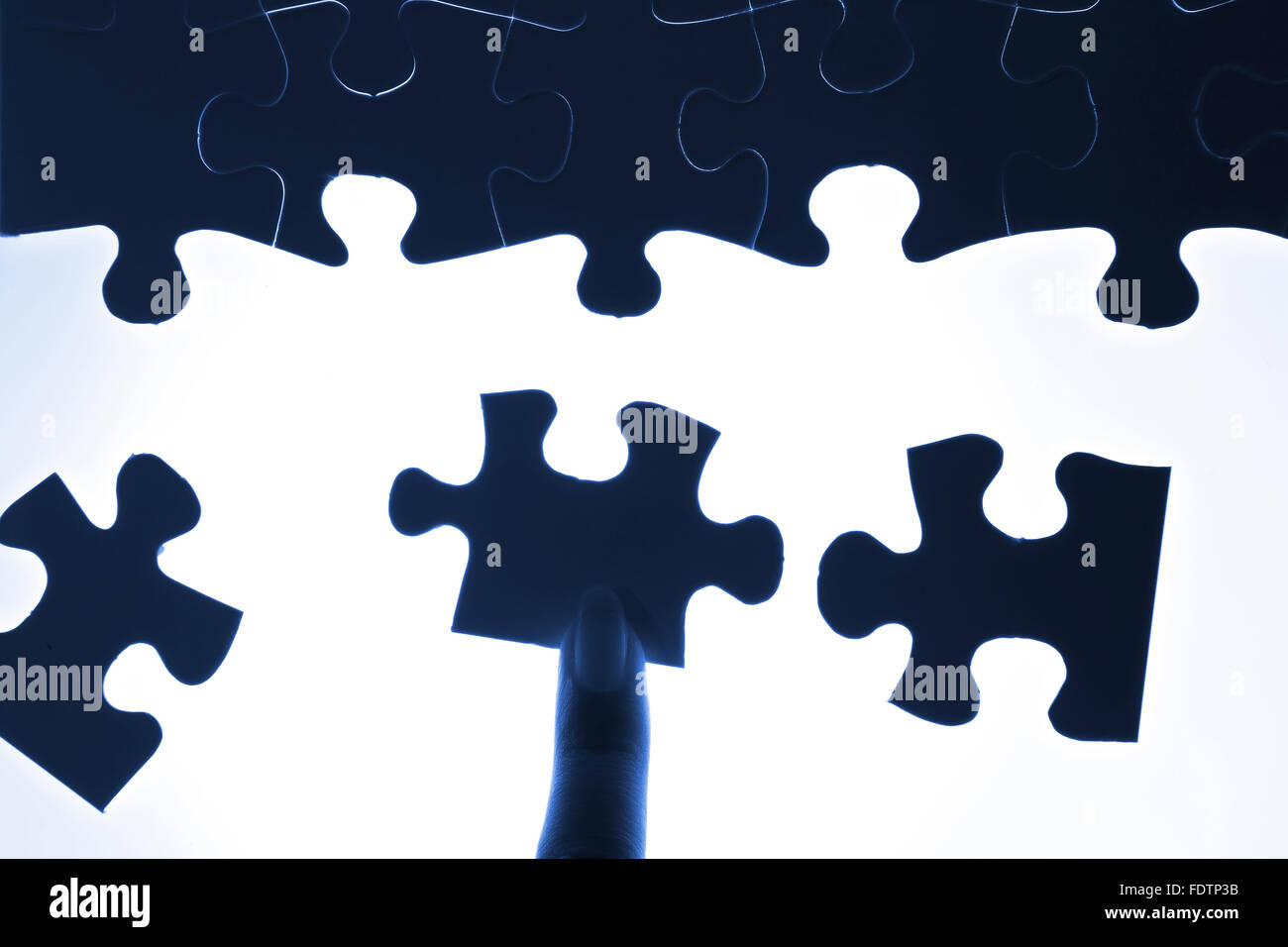 puzzle piece coming down into its place Stock Photo - Alamy