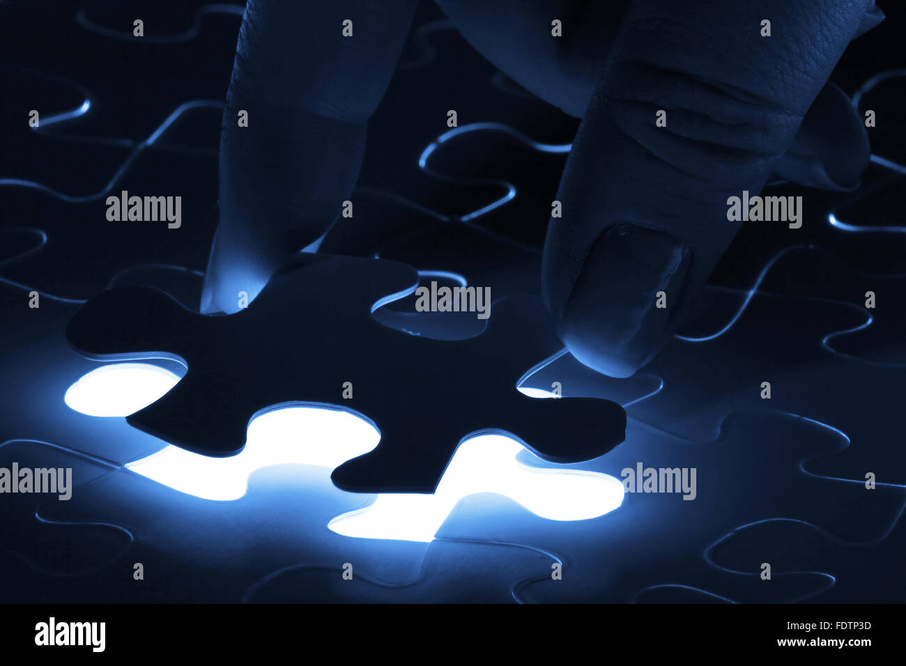 puzzle piece coming down into its place Stock Photo - Alamy