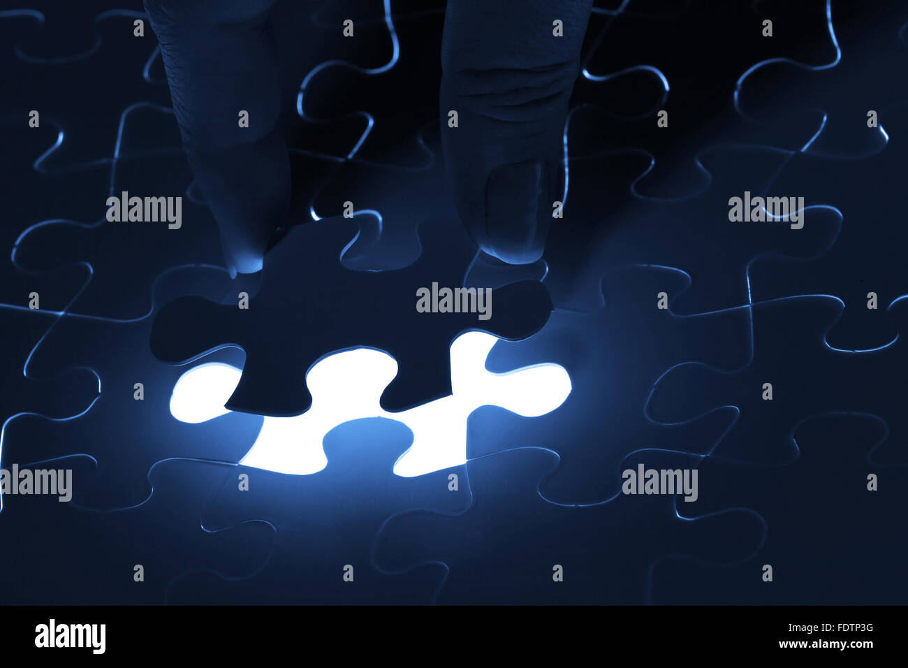 puzzle piece coming down into its place Stock Photo - Alamy